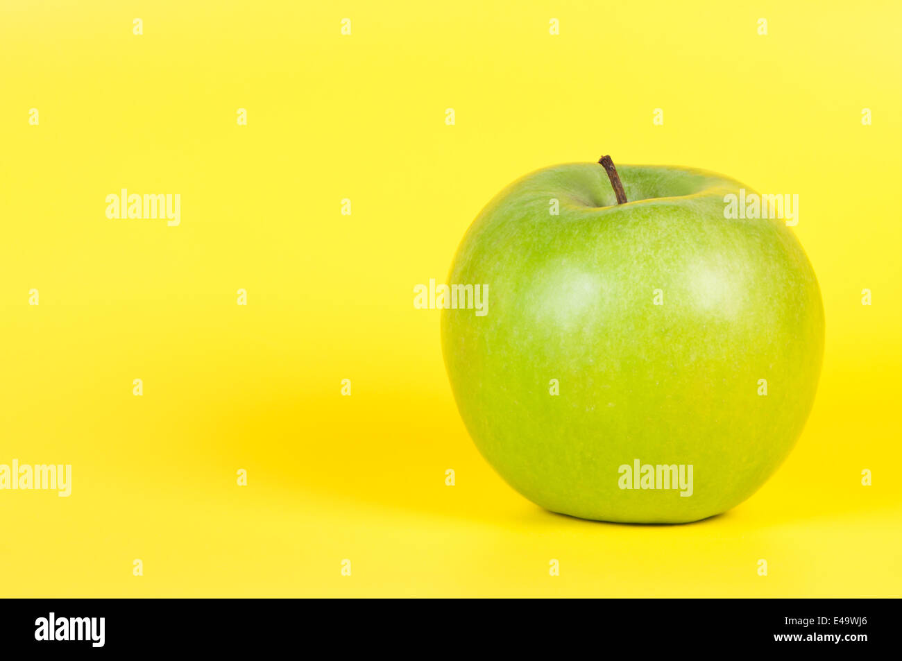 Apple on a yellow background Stock Photo - Alamy