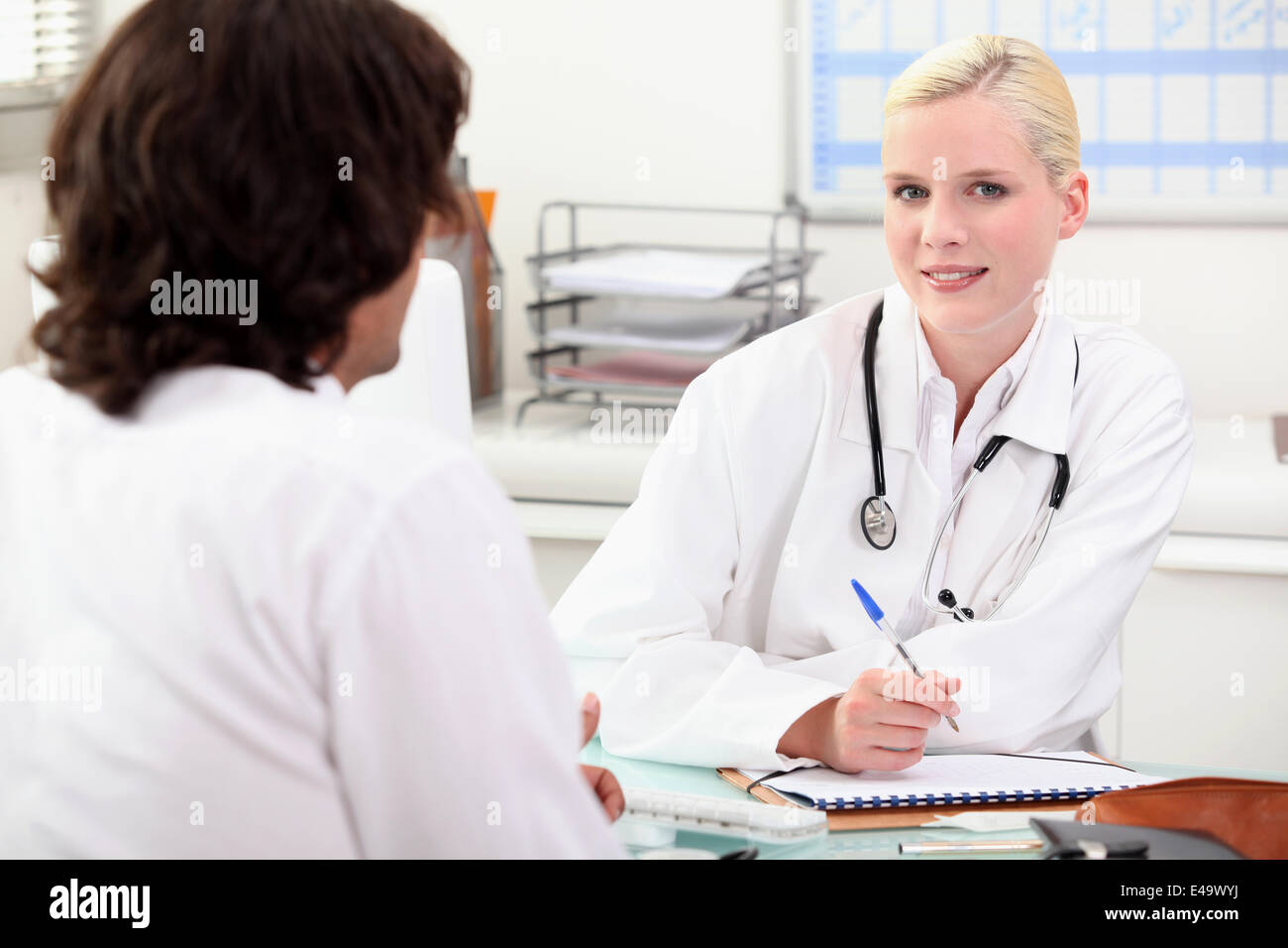 Doctor consulting with a patient Stock Photo - Alamy