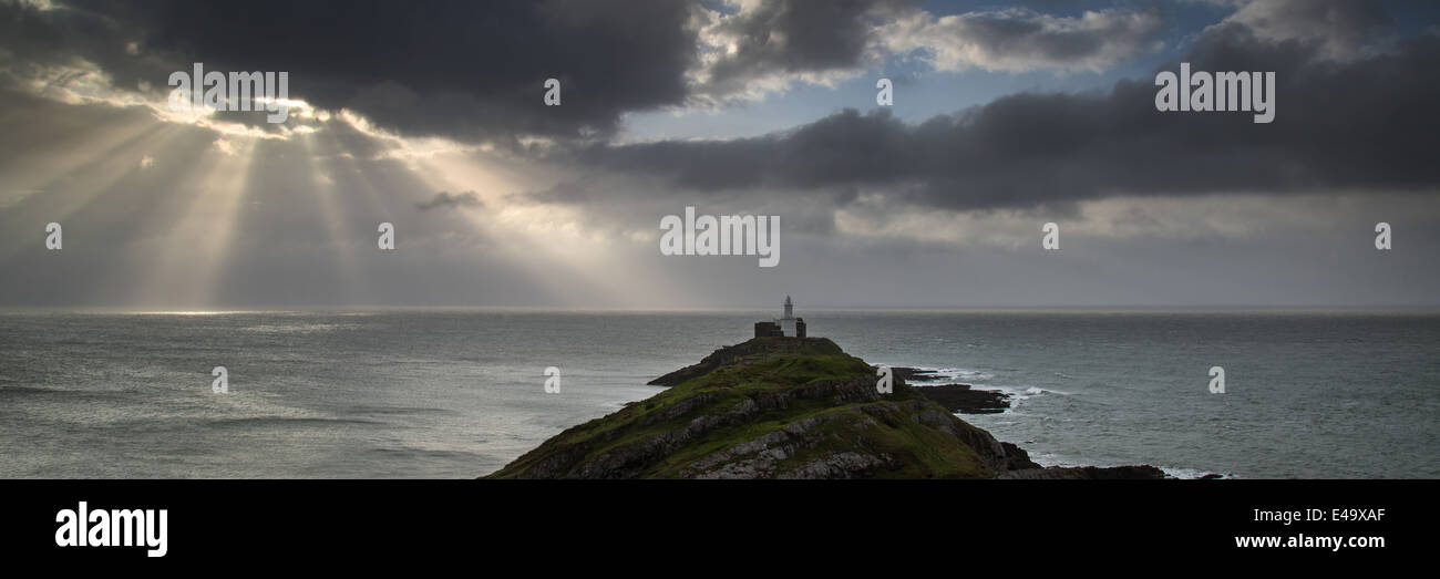 Landscape panorama of Mumbles lighthouse in Wales with sun beams over ...