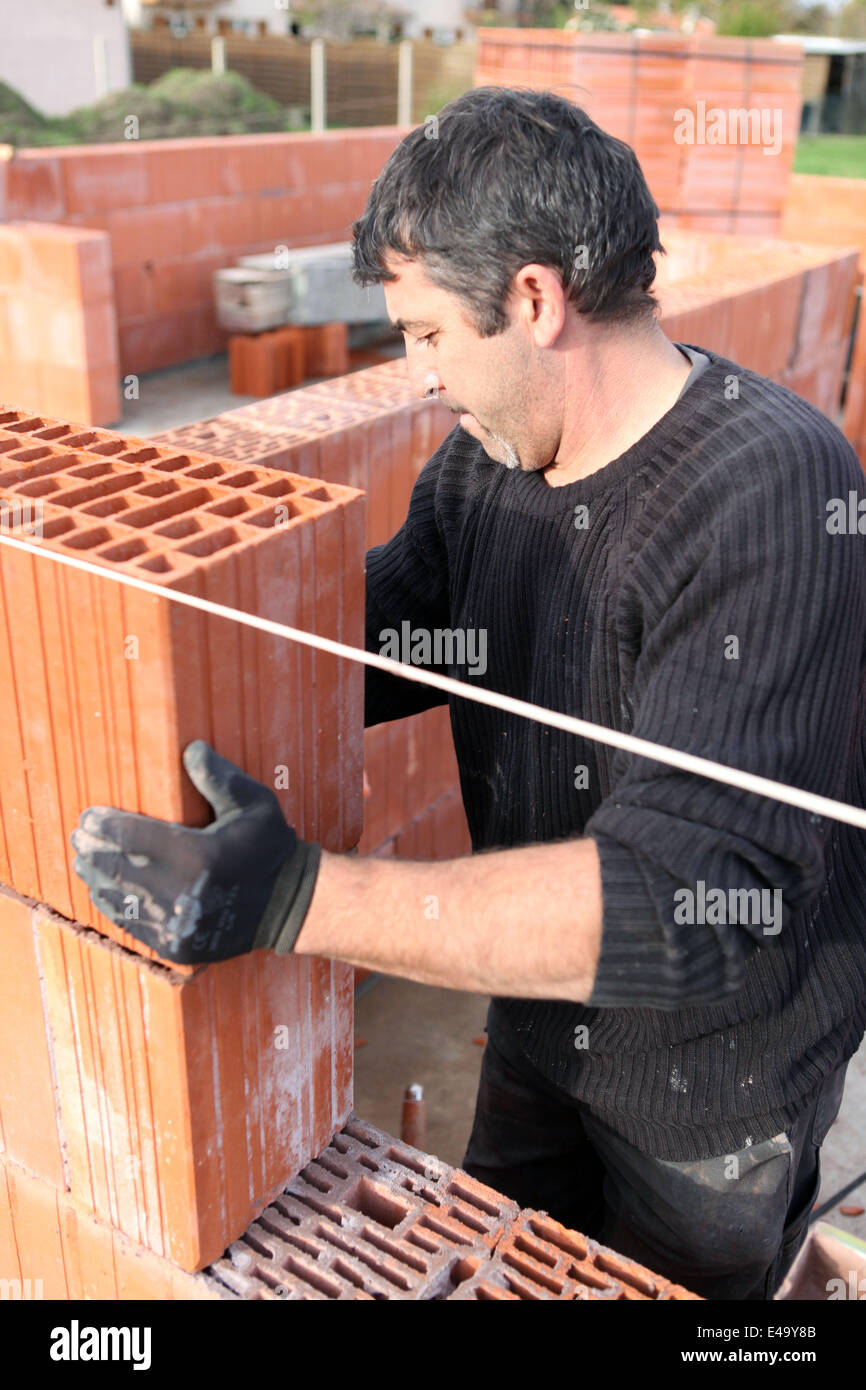 Bricklayer building wall Stock Photo - Alamy