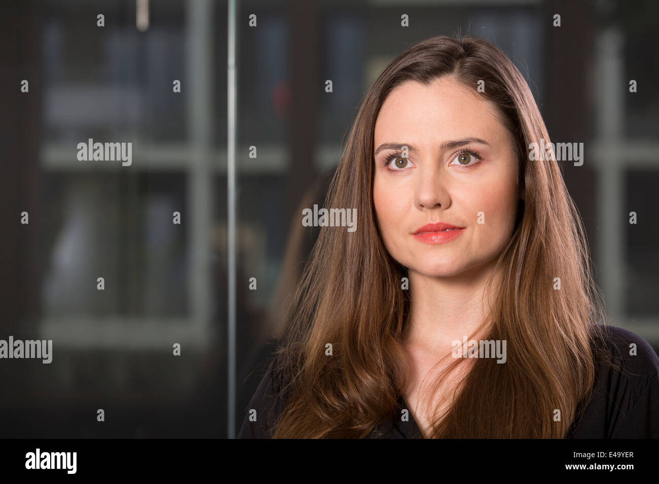 Portrait of business woman in front of glass pane Stock Photo - Alamy
