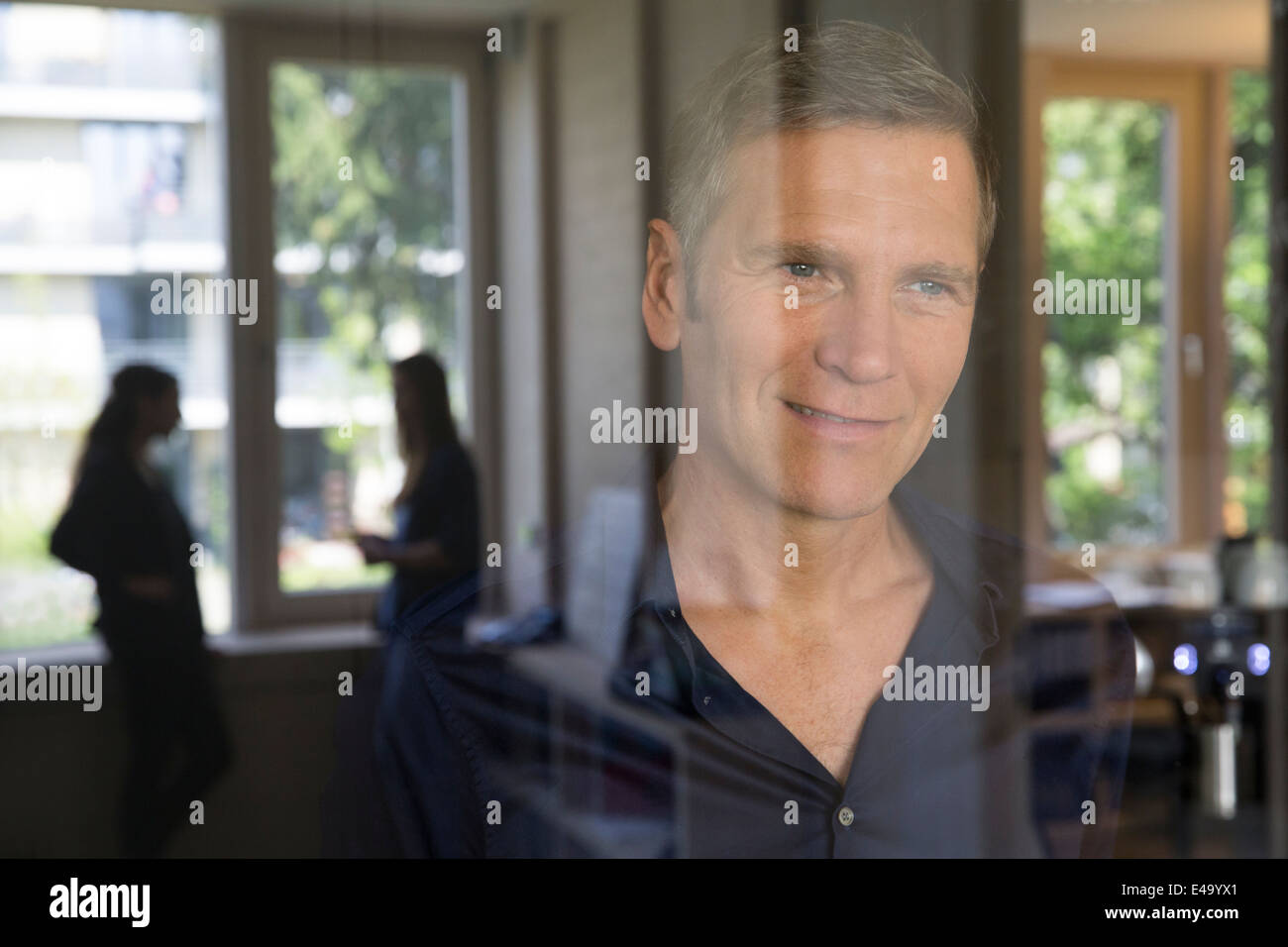 Portrait of smiling business man behind glass pane Stock Photo - Alamy