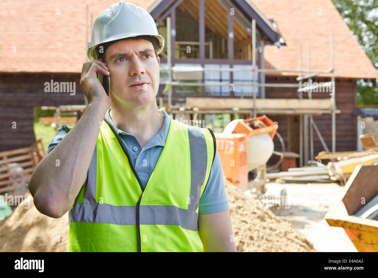 Construction Worker On Building Site Using Mobile Phone Stock Photo - Alamy