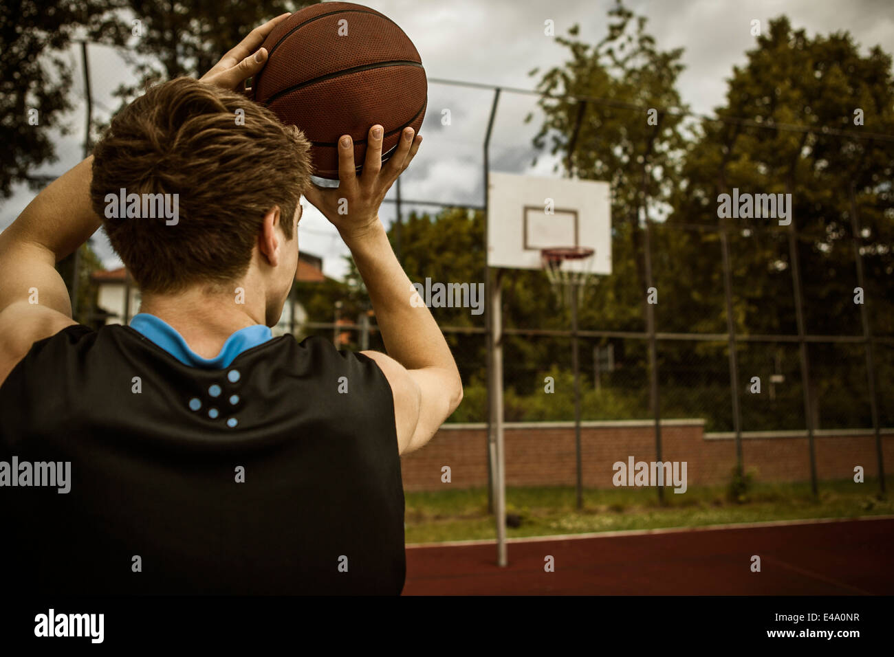 Young basketball player aiming for basketball hoop, back view Stock ...