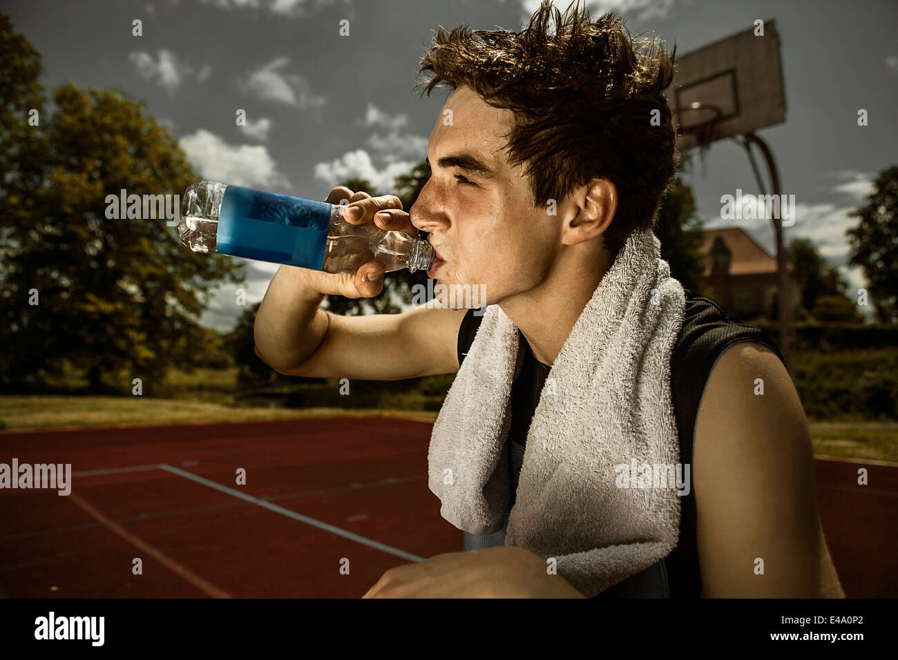 Portrait of young basketball player drinking water out of bottle Stock ...