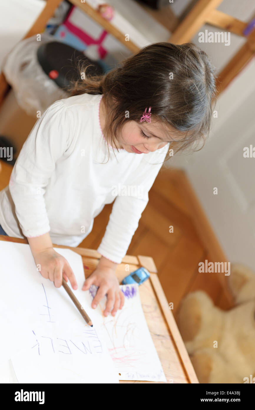 Girl at home writing on sheet of paper Stock Photo - Alamy