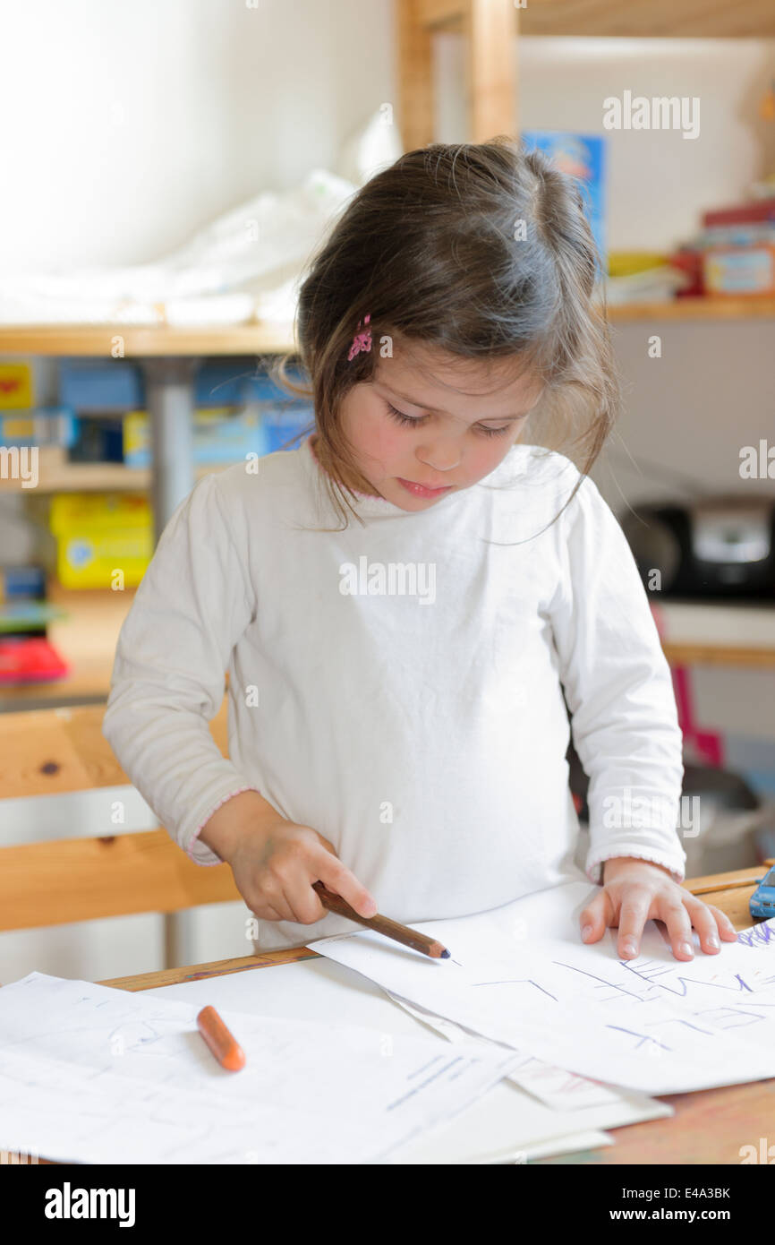 Girl at home writing on sheet of paper Stock Photo - Alamy