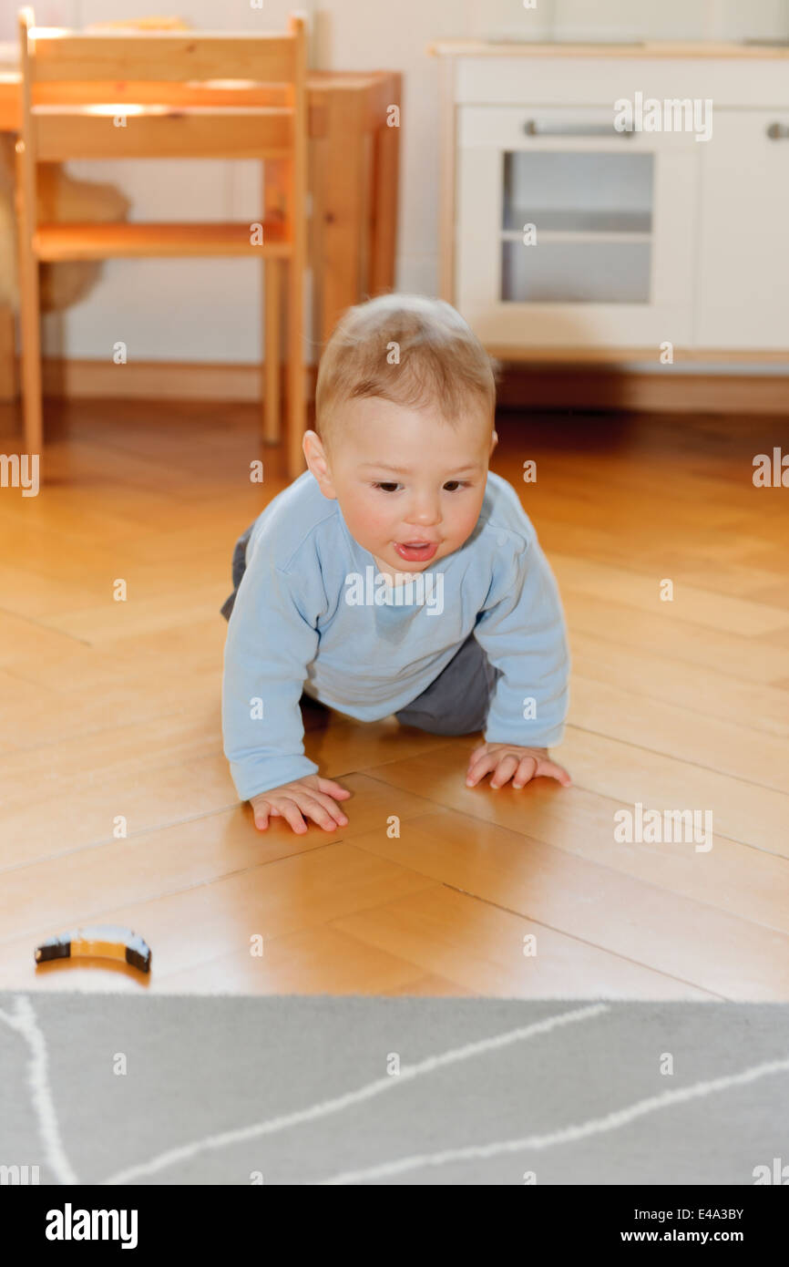 Baby boy at home crawling on the floor Stock Photo - Alamy