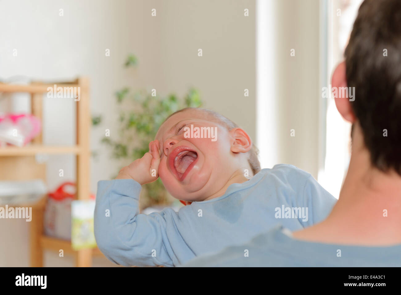 Father holding crying baby boy Stock Photo - Alamy