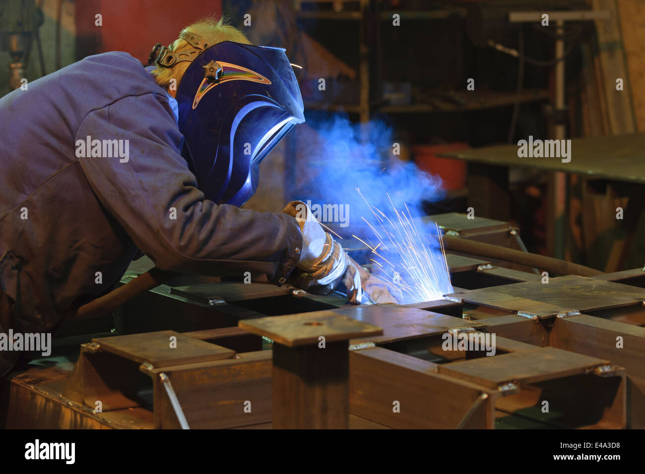 Man welding in a scrap metal recycling plant Stock Photo - Alamy