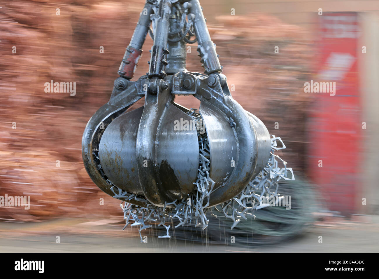 Clamshell grabbing stainless steel chunks in a scrap metal recycling ...