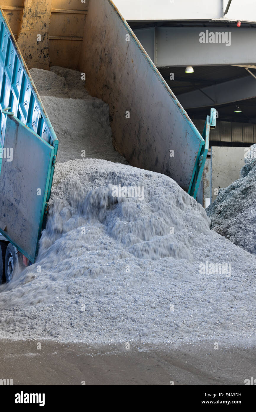 Dump truck unloading aluminium chips in a scrap metal recycling plant ...