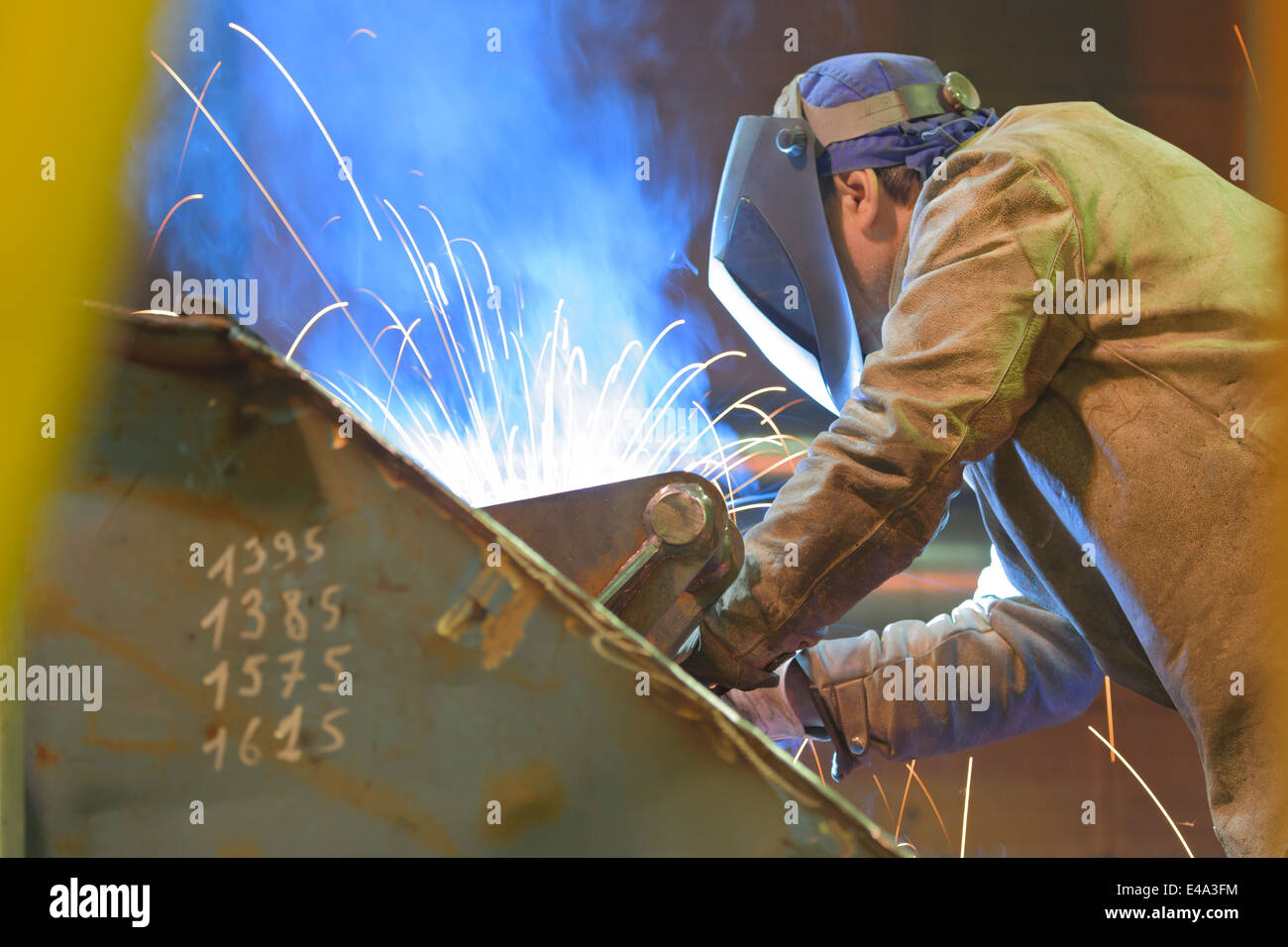 Man welding in a scrap metal recycling plant Stock Photo - Alamy