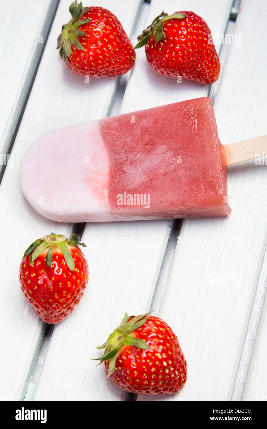 Strawberry ice cream lolly and strawberries on white wood Stock Photo ...