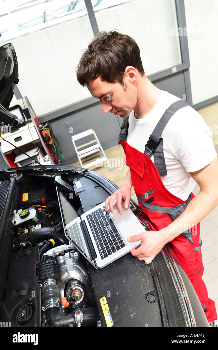 Car mechanic in a workshop using modern diagnostic equipment Stock ...