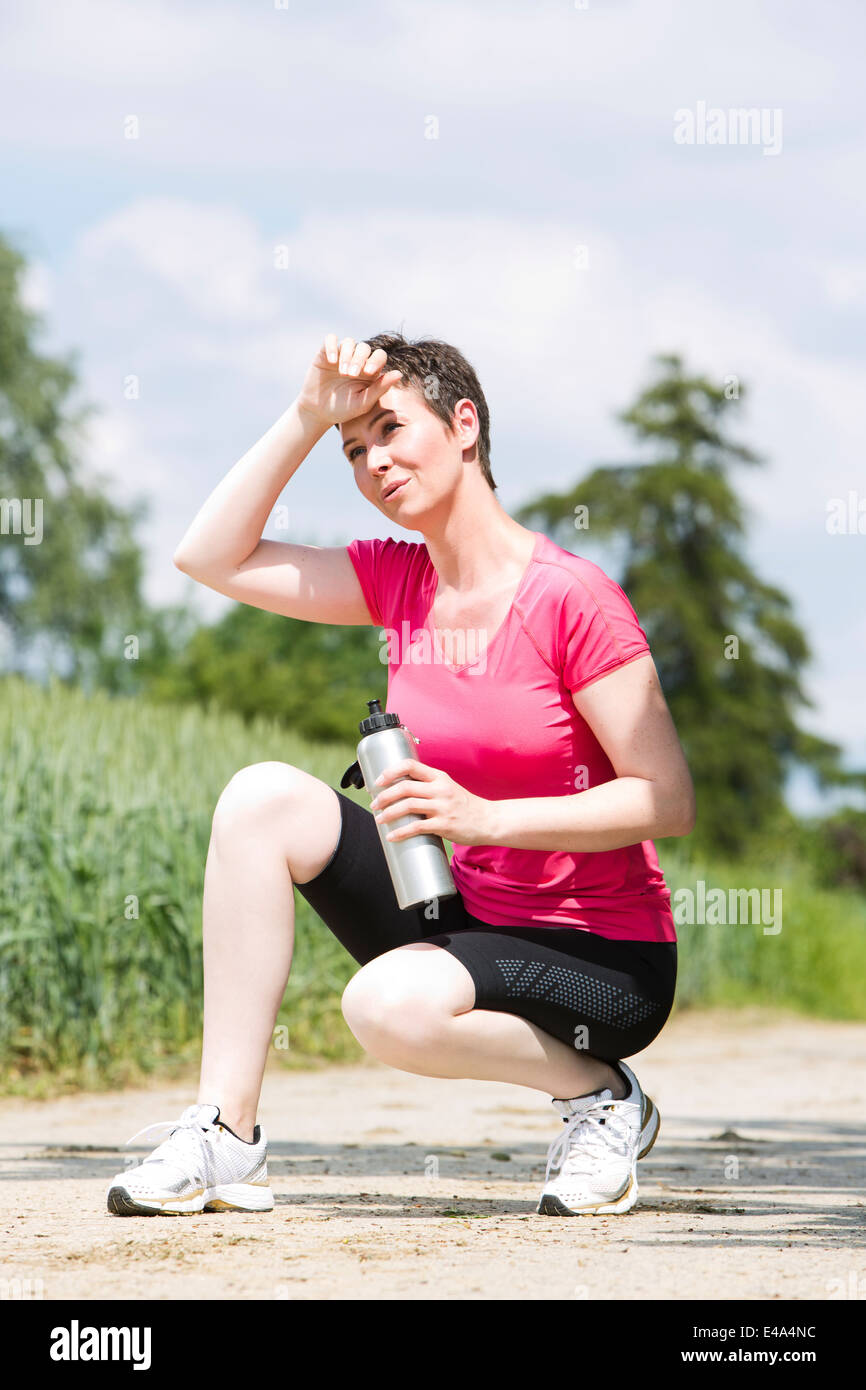 Female jogger relaxing after running Stock Photo - Alamy