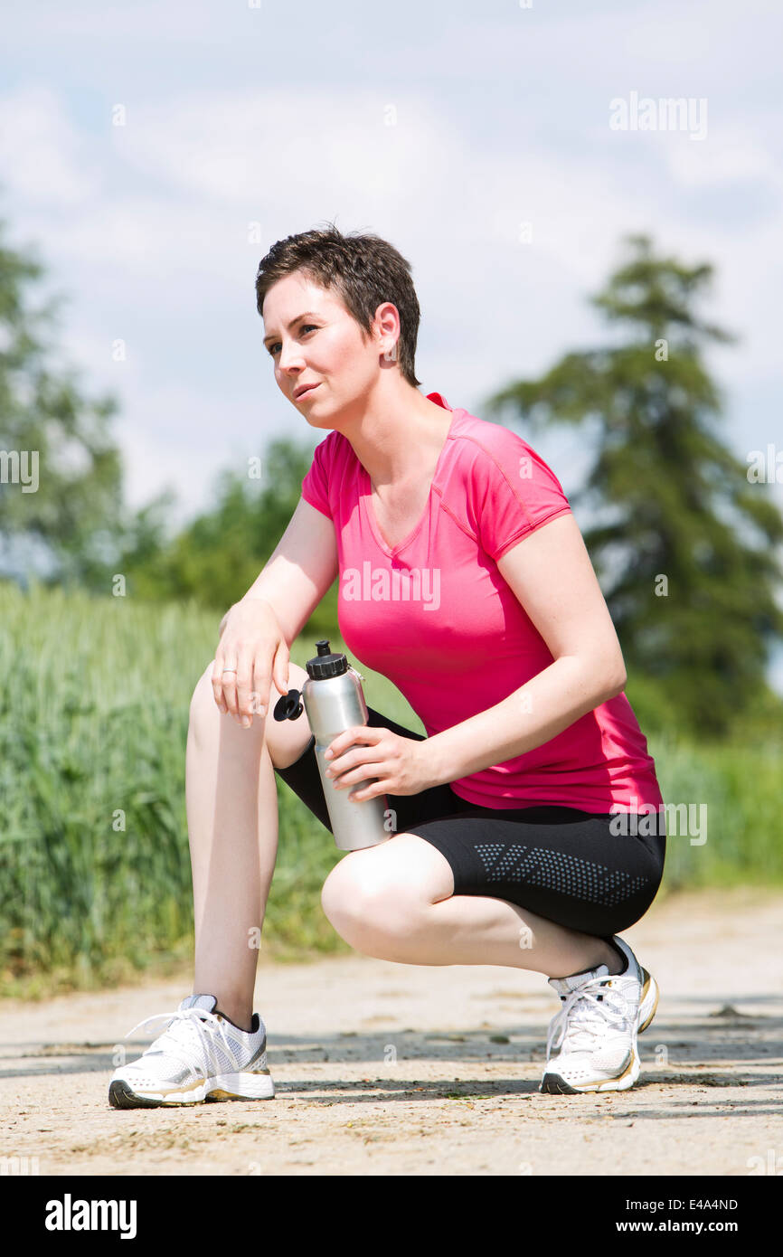 Female jogger relaxing after running Stock Photo - Alamy