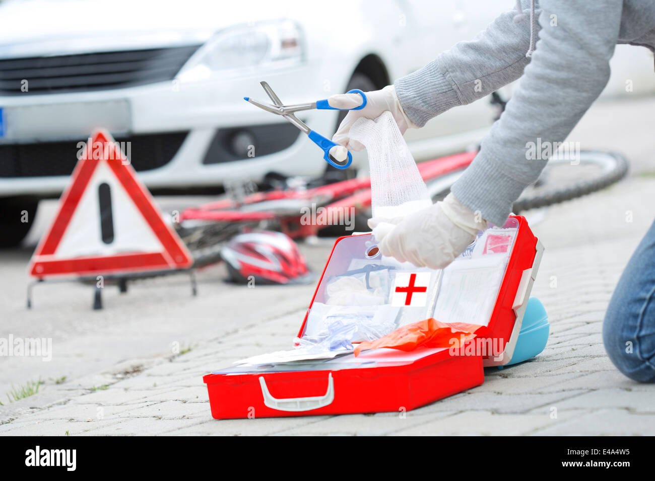 Woman applying first aid at crash scene, partial view Stock Photo - Alamy