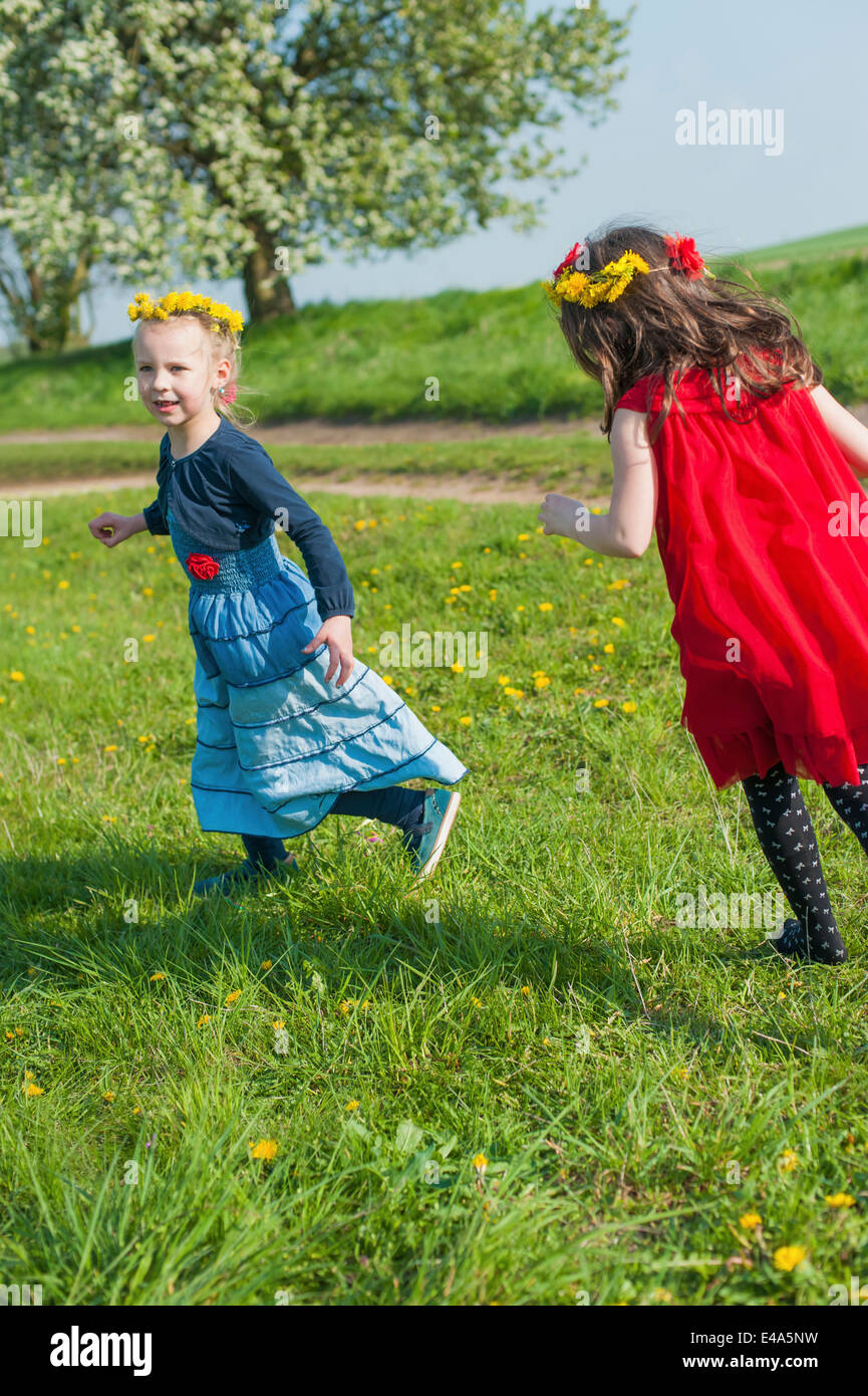 Two little girls running on a meadow Stock Photo - Alamy