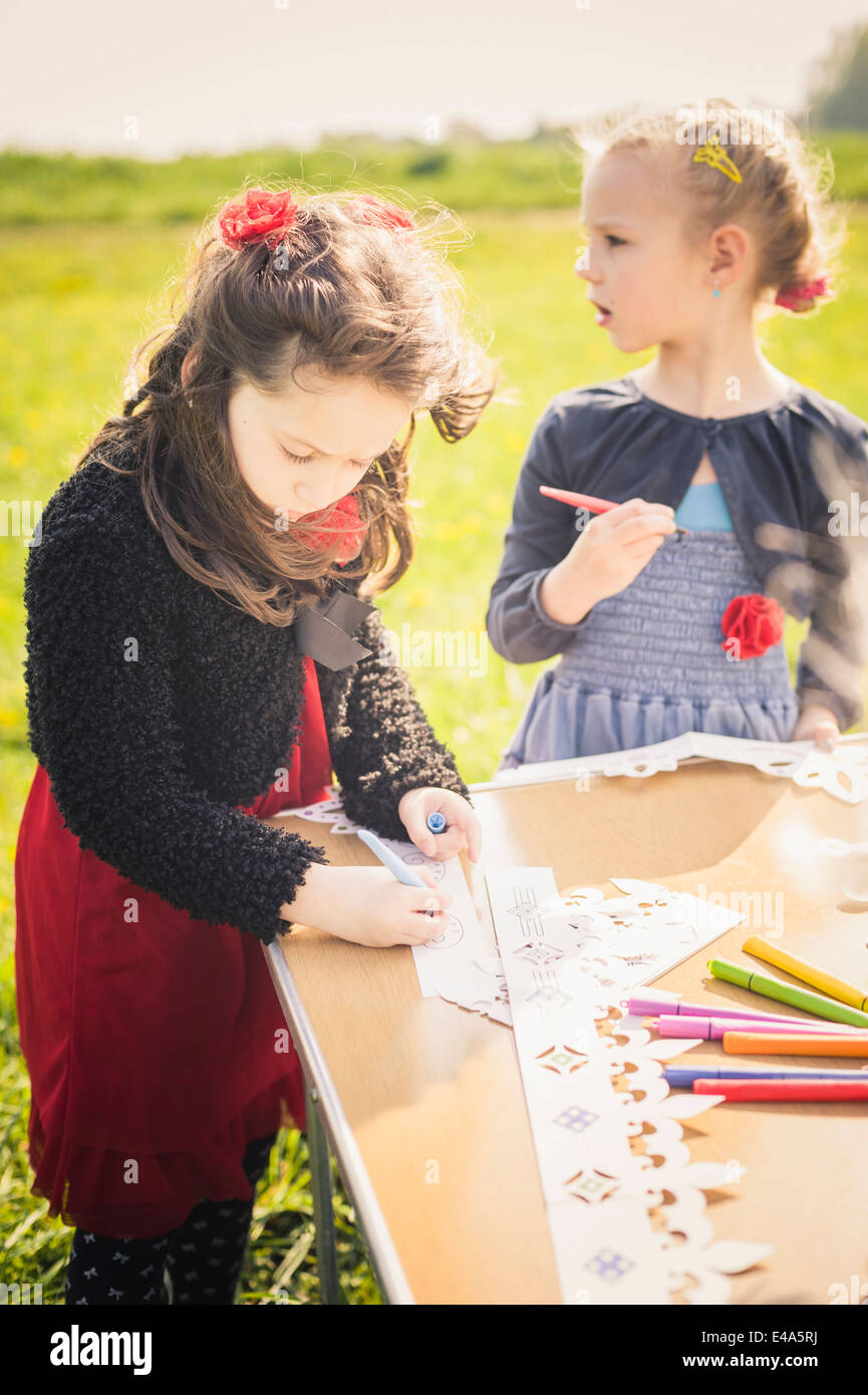 Two little girls painting paper crowns for birthday party Stock Photo ...