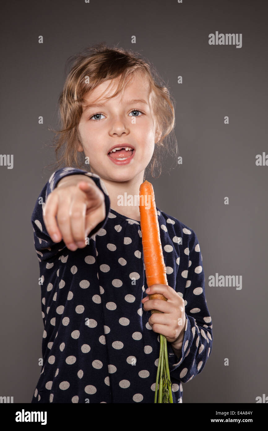 Portrait of little girl using carrot as a microphone Stock Photo - Alamy