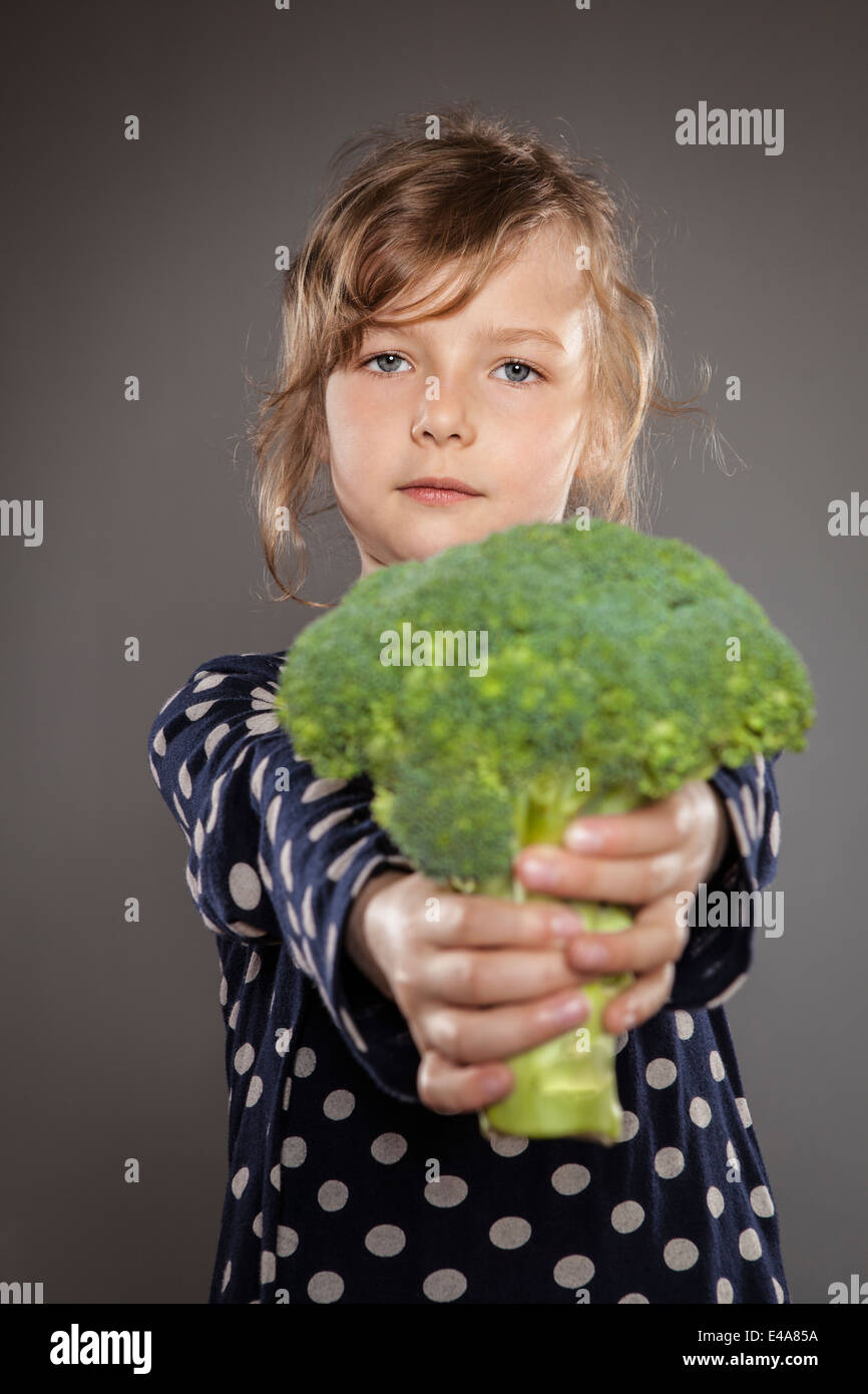Portrait of little girl holding broccoli Stock Photo - Alamy