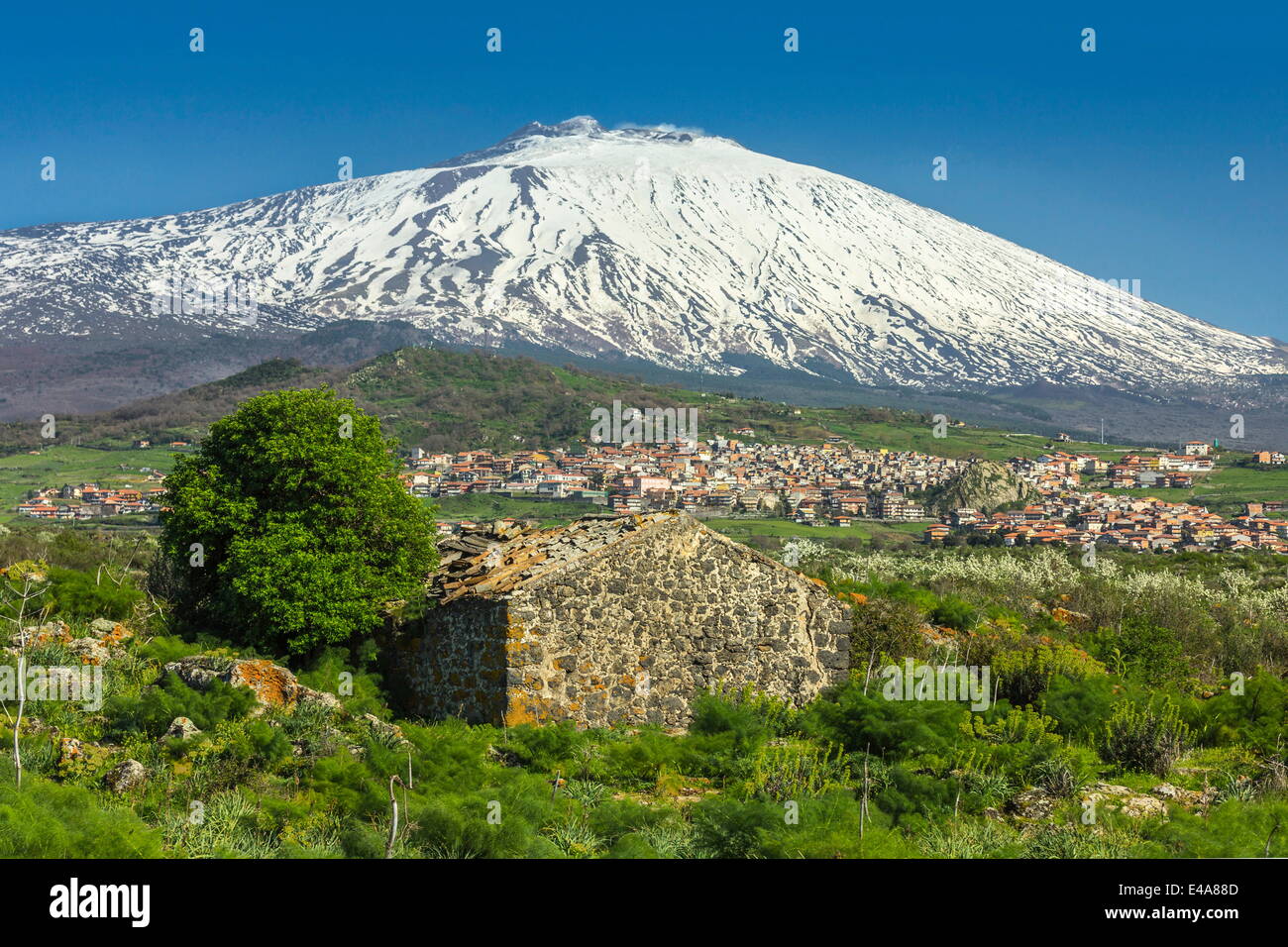Snow-capped volcano Mount Etna, UNESCO, looms over the Maletto, Catania ...