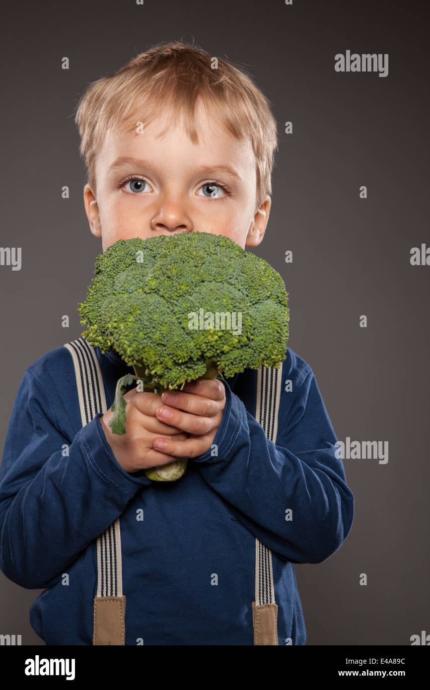 Portrait of little boy holding broccoli Stock Photo - Alamy