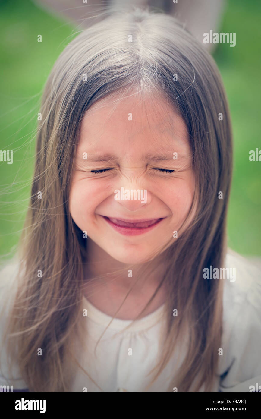 Portrait of little girl squinting eyes Stock Photo - Alamy