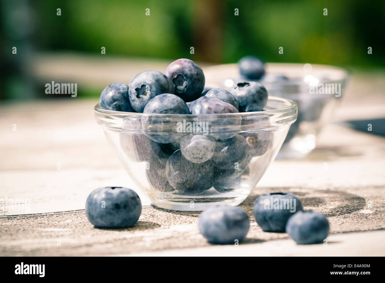 Glass bowls of blueberries on wooden table Stock Photo - Alamy