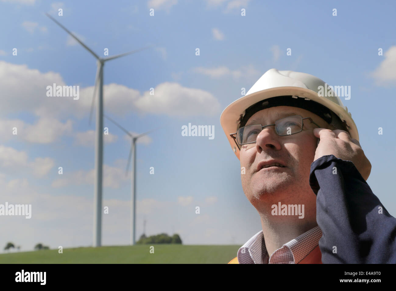 Germany, technician with safety helmet in front of wind turbines Stock ...