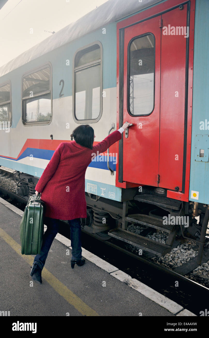 Mid adult woman late for the train Stock Photo - Alamy