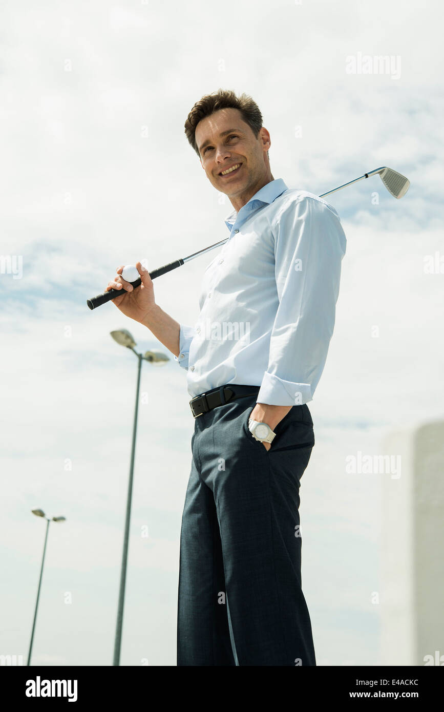 Smiling business man with golf club Stock Photo - Alamy