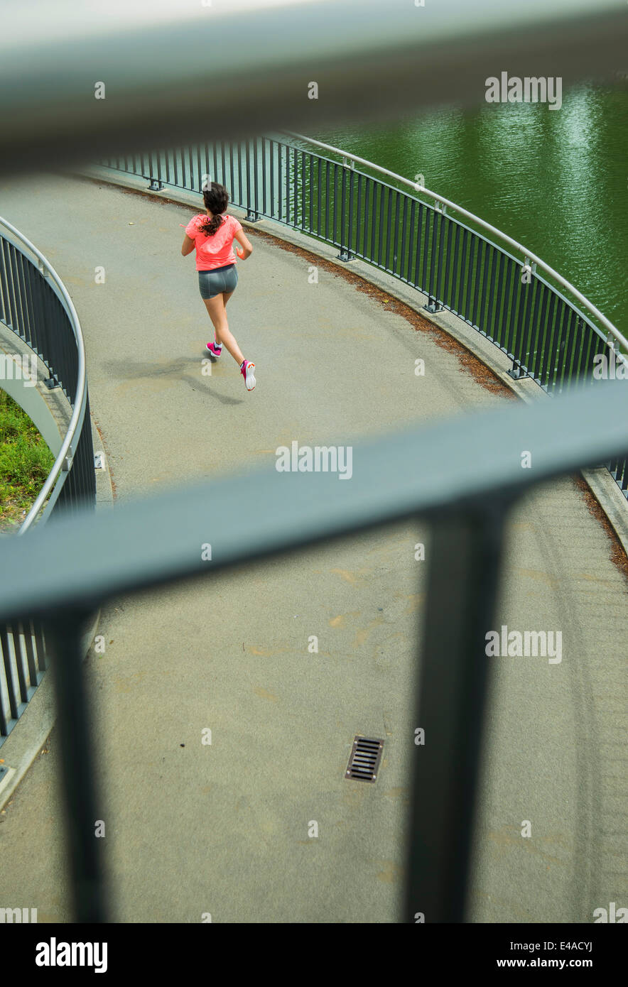 Young woman jogging on a bridge, back view Stock Photo - Alamy