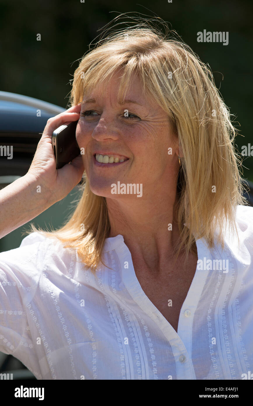 Portrait Of An Attractive Blonde Mid Aged Woman Using A Mobile Phone
