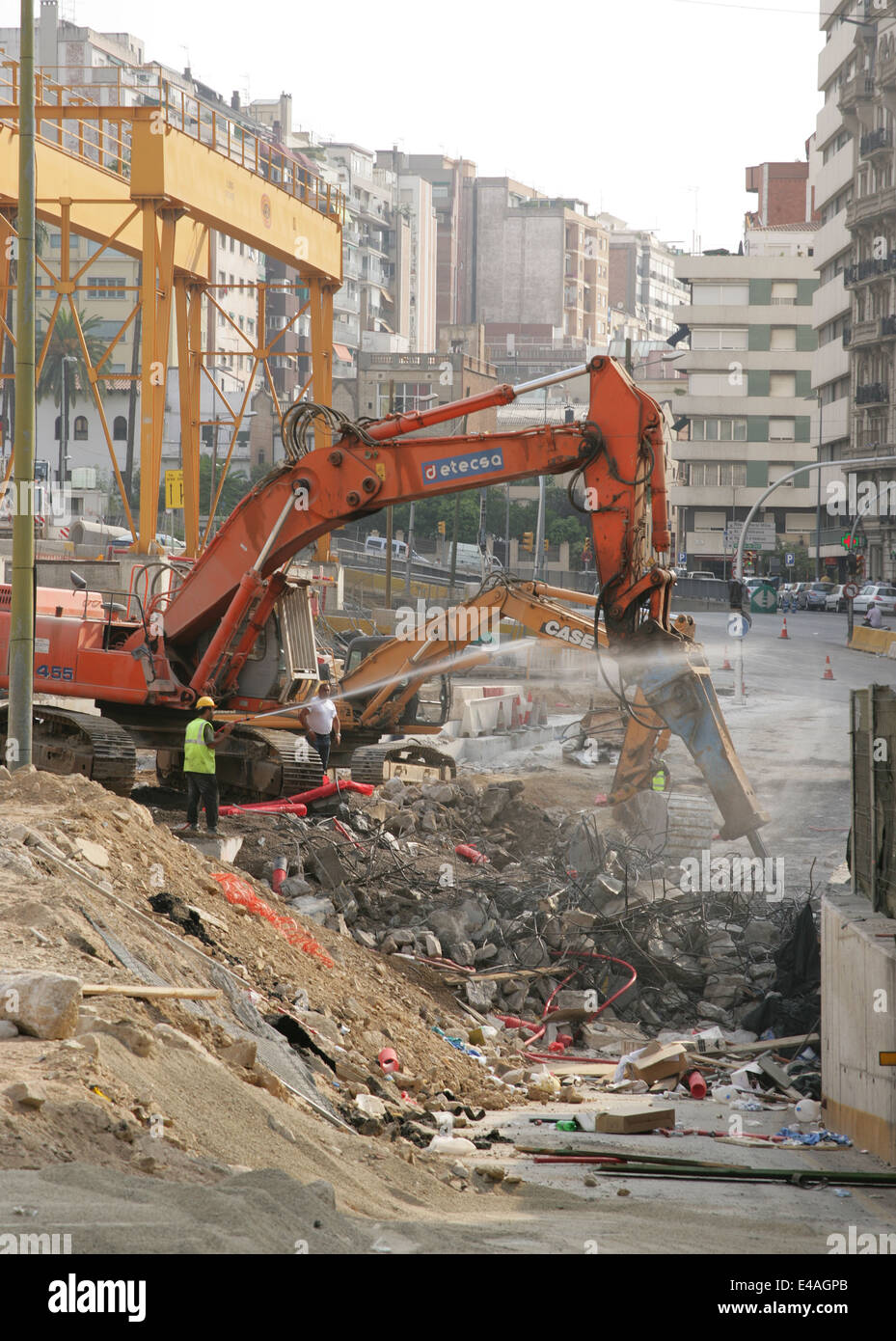 Breaking up concrete road surface with a pneumatic hammer and excavator ...