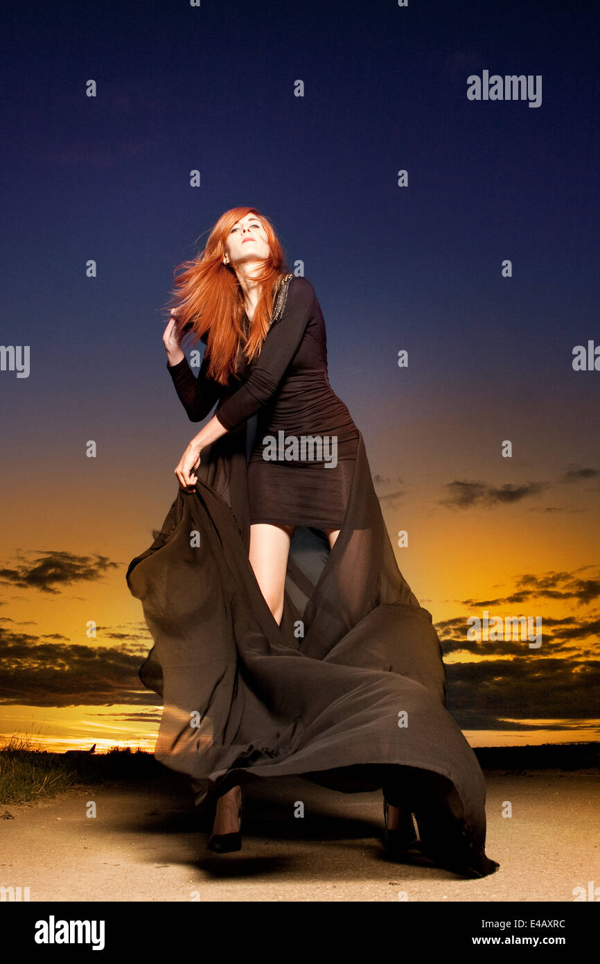 Beautiful woman with glossy red hair dancing with long chiffon shawl ...