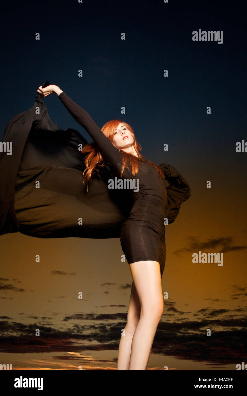 Beautiful woman with glossy red hair dancing with long chiffon shawl ...