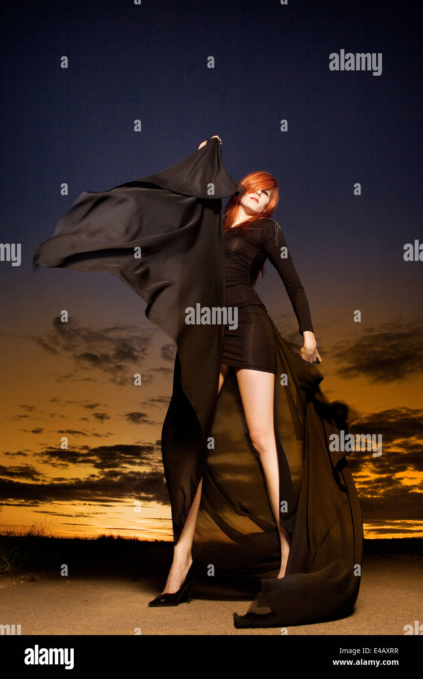 Beautiful woman with glossy red hair dancing with long chiffon shawl ...