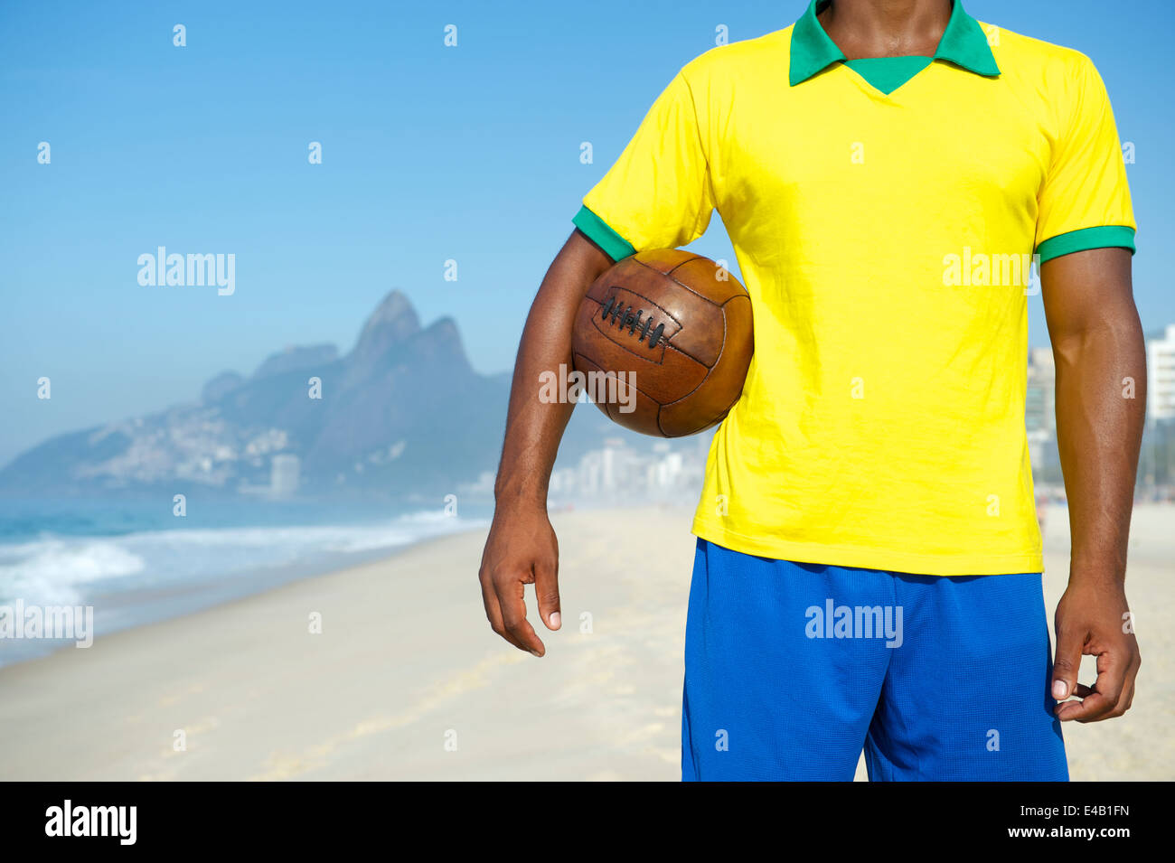 Brazilian soccer player in Brazil colors holding vintage football ...