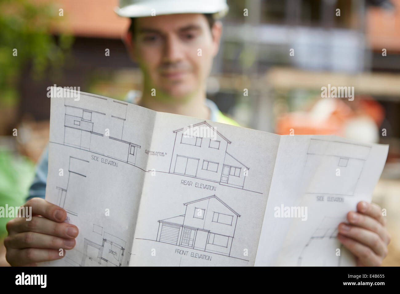 Construction Worker On Building Site Looking At House Plans Stock Photo ...