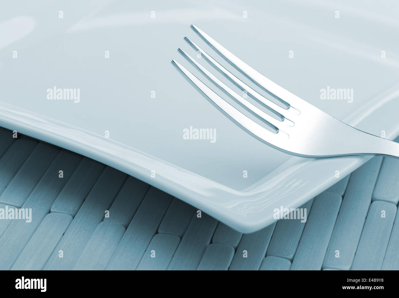 Fork laying on a plate Stock Photo - Alamy