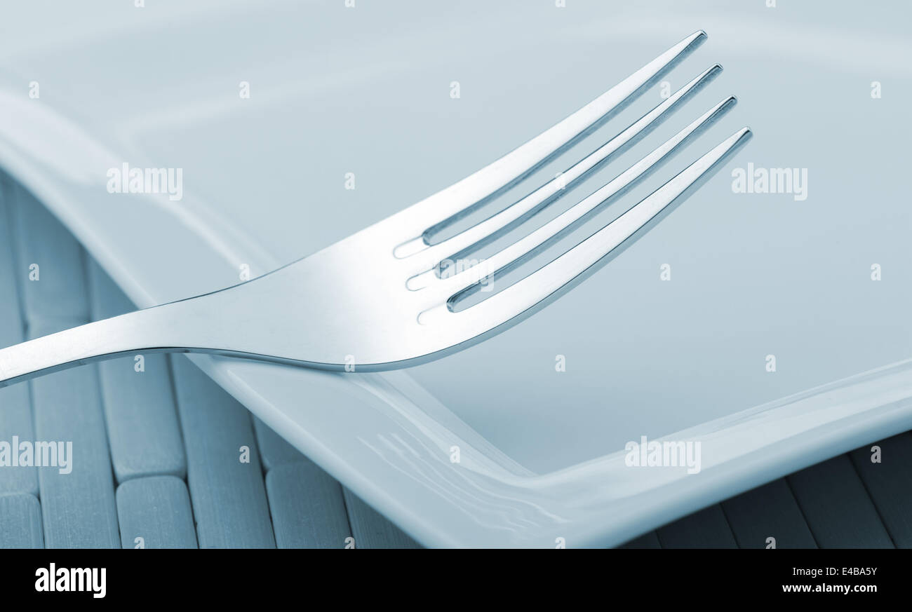 Fork laying on a plate Stock Photo - Alamy