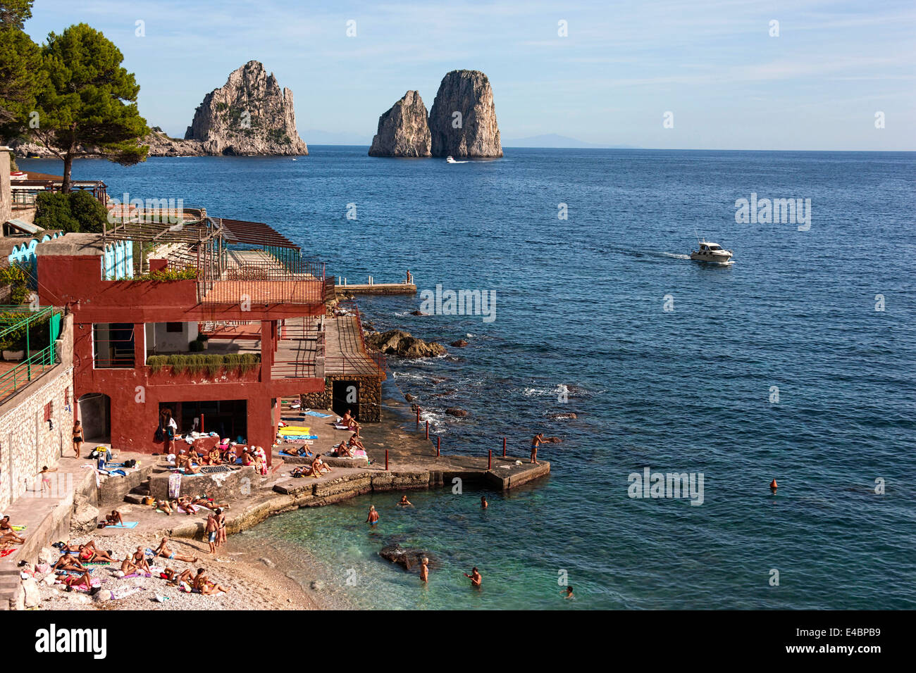 Sunbathers and swimmers with the Faraglioni Rocks in background, Marina ...