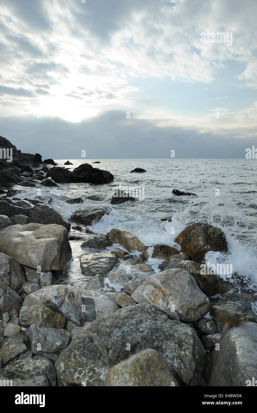 Splash of waves about coastal stones Stock Photo - Alamy