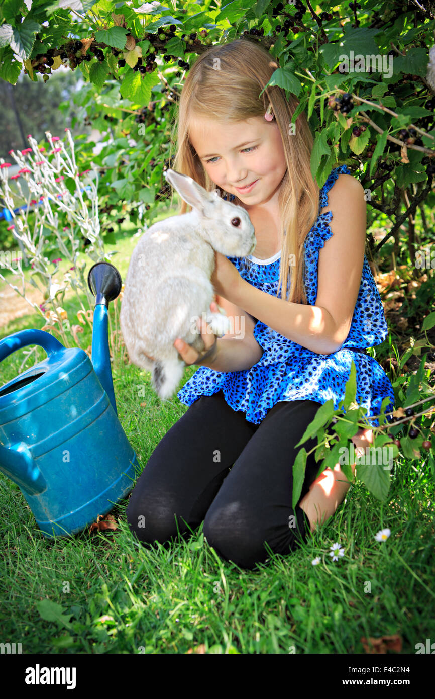 Teenage girl playing with a rabbit in the backyard Stock Photo - Alamy