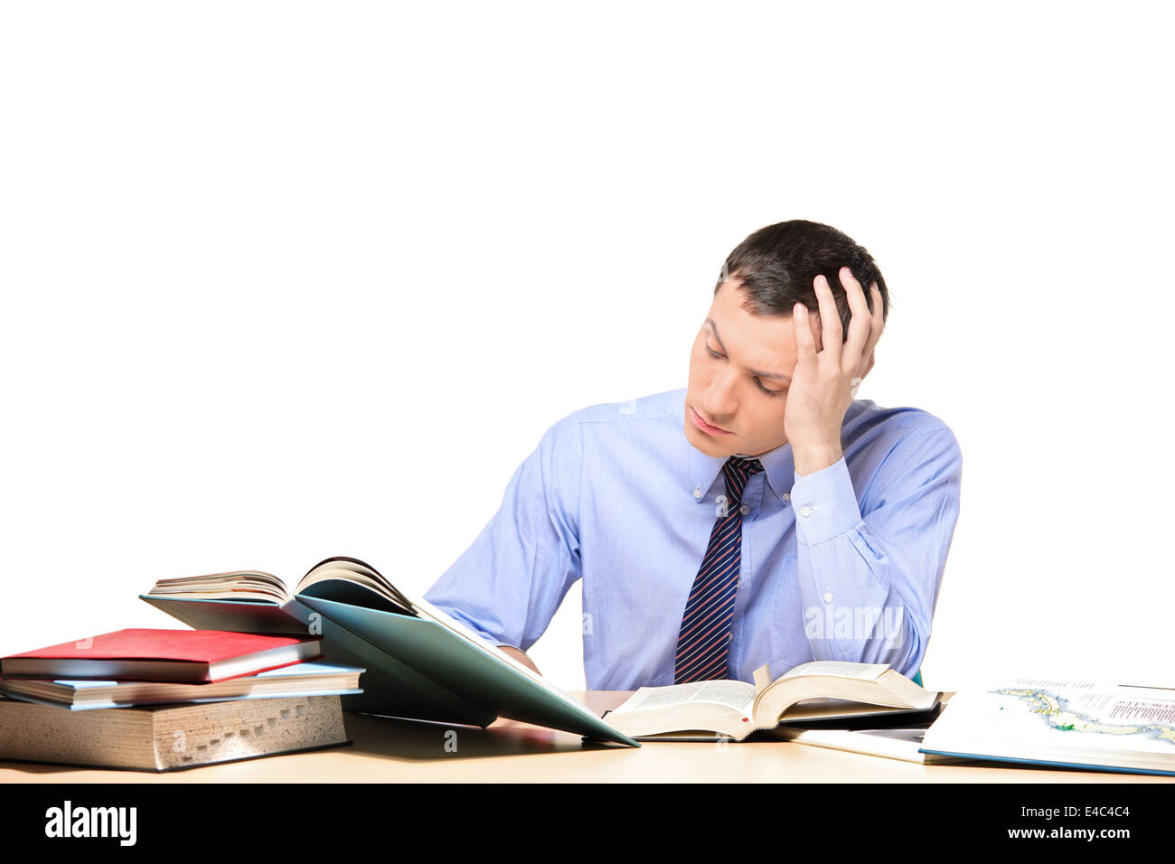 Young man studying some problem seated at a table Stock Photo - Alamy