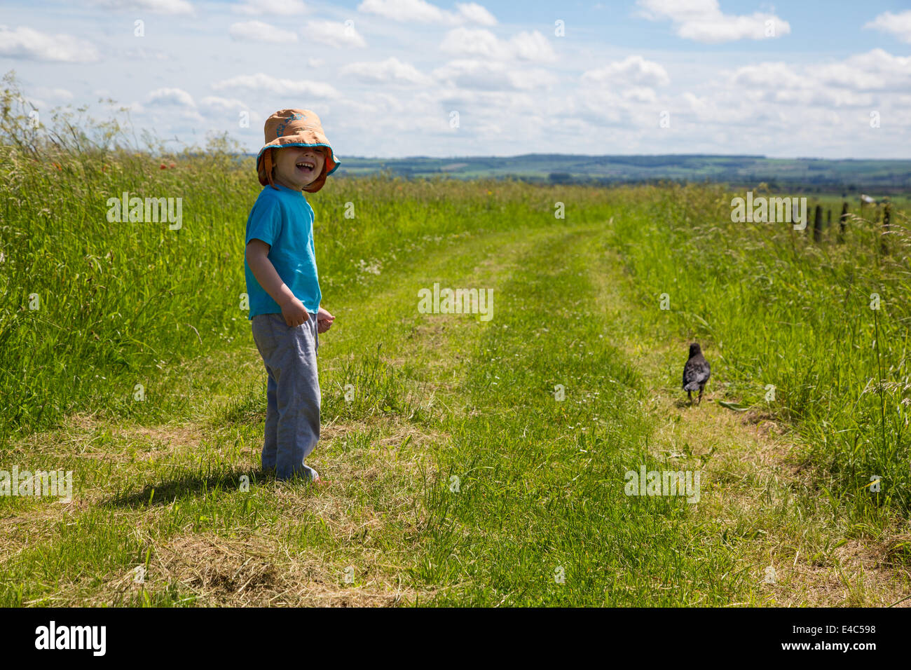 Small boy following a Crow Stock Photo - Alamy