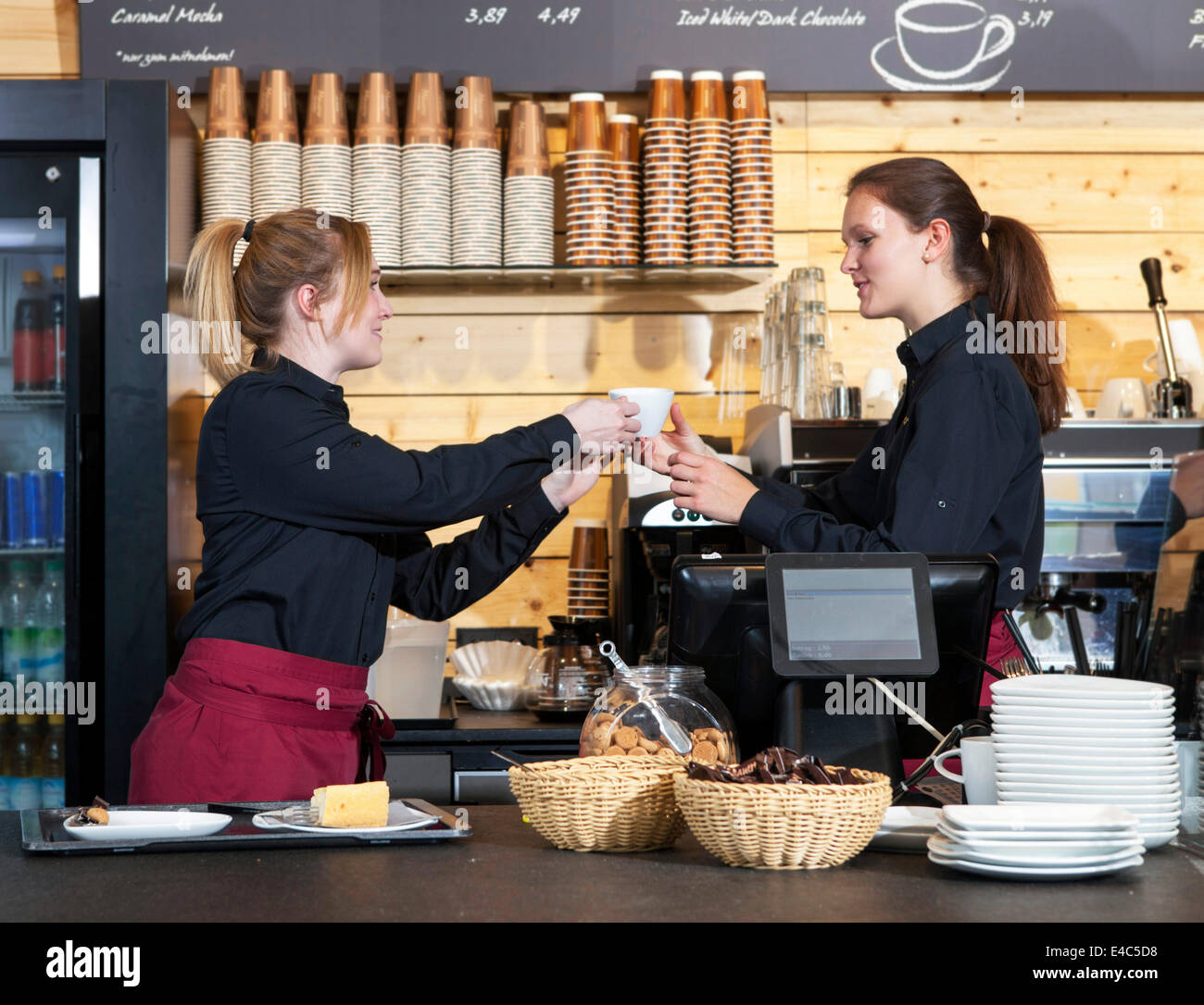 Female shop assistants working together in coffee shop Stock Photo - Alamy