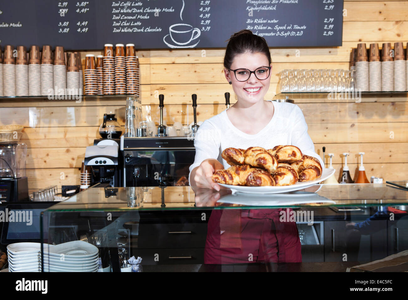 Waitress in coffee shop arranging croissants on counter Stock Photo - Alamy